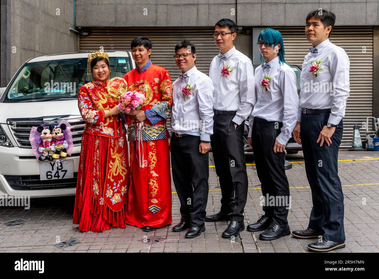 Une fête de mariage chinoise avec la mariée et le marié en costume traditionnel pose pour des ...
