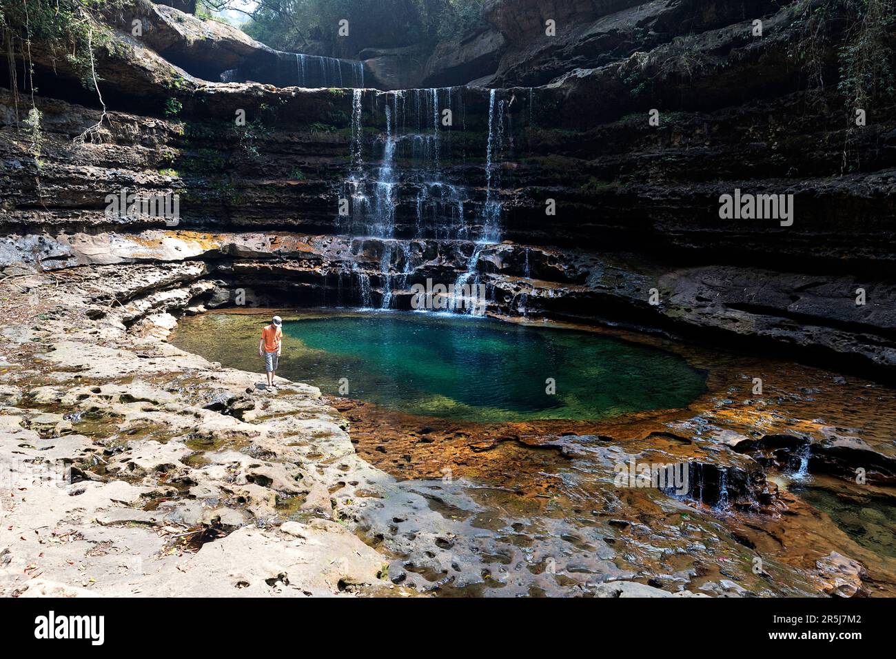 Touriste appréciant à côté de la piscine immaculée de belles cascades ...