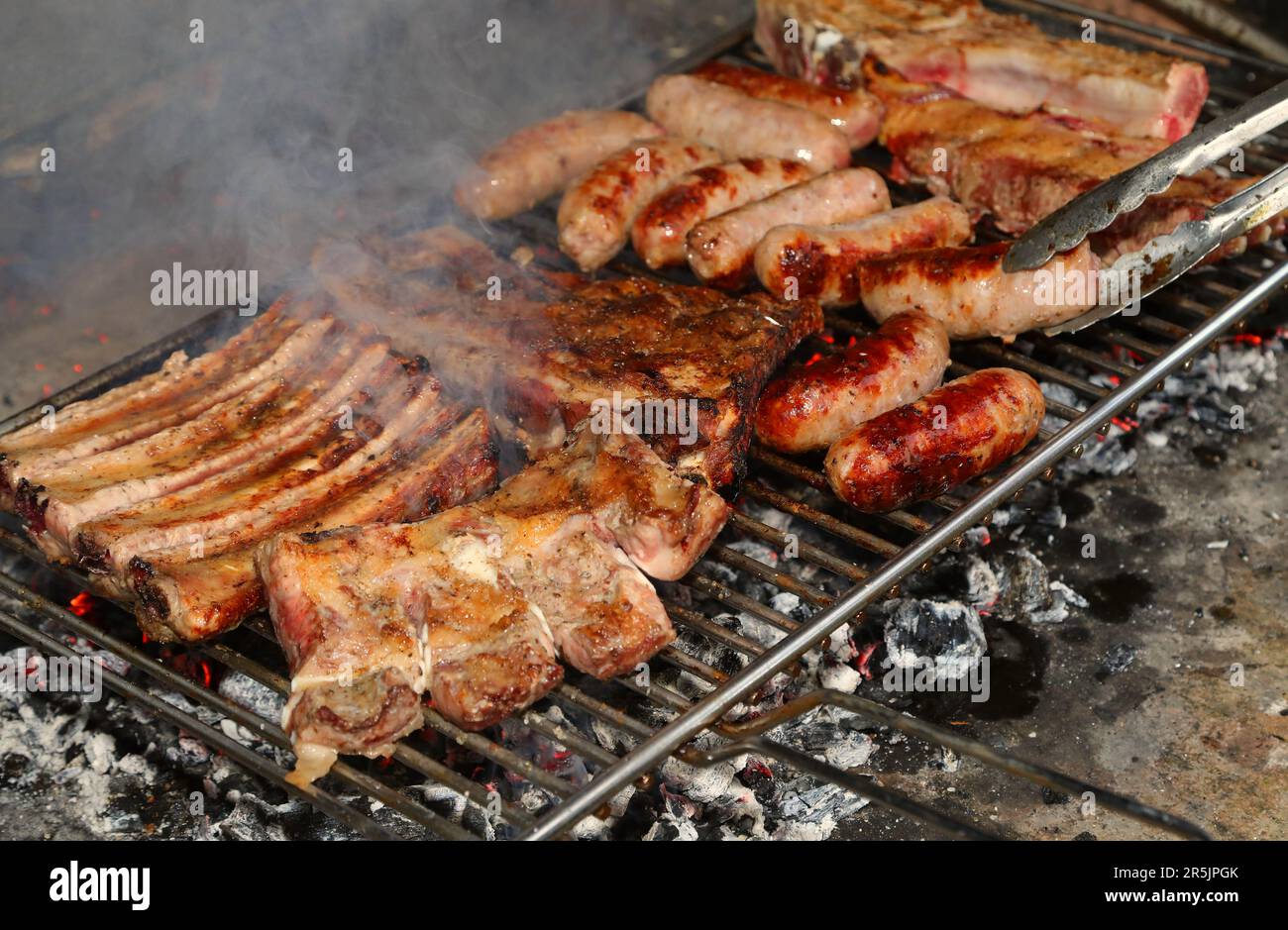 Barbecue grillé cuisant avec des saucisses et des côtes de rechange ...