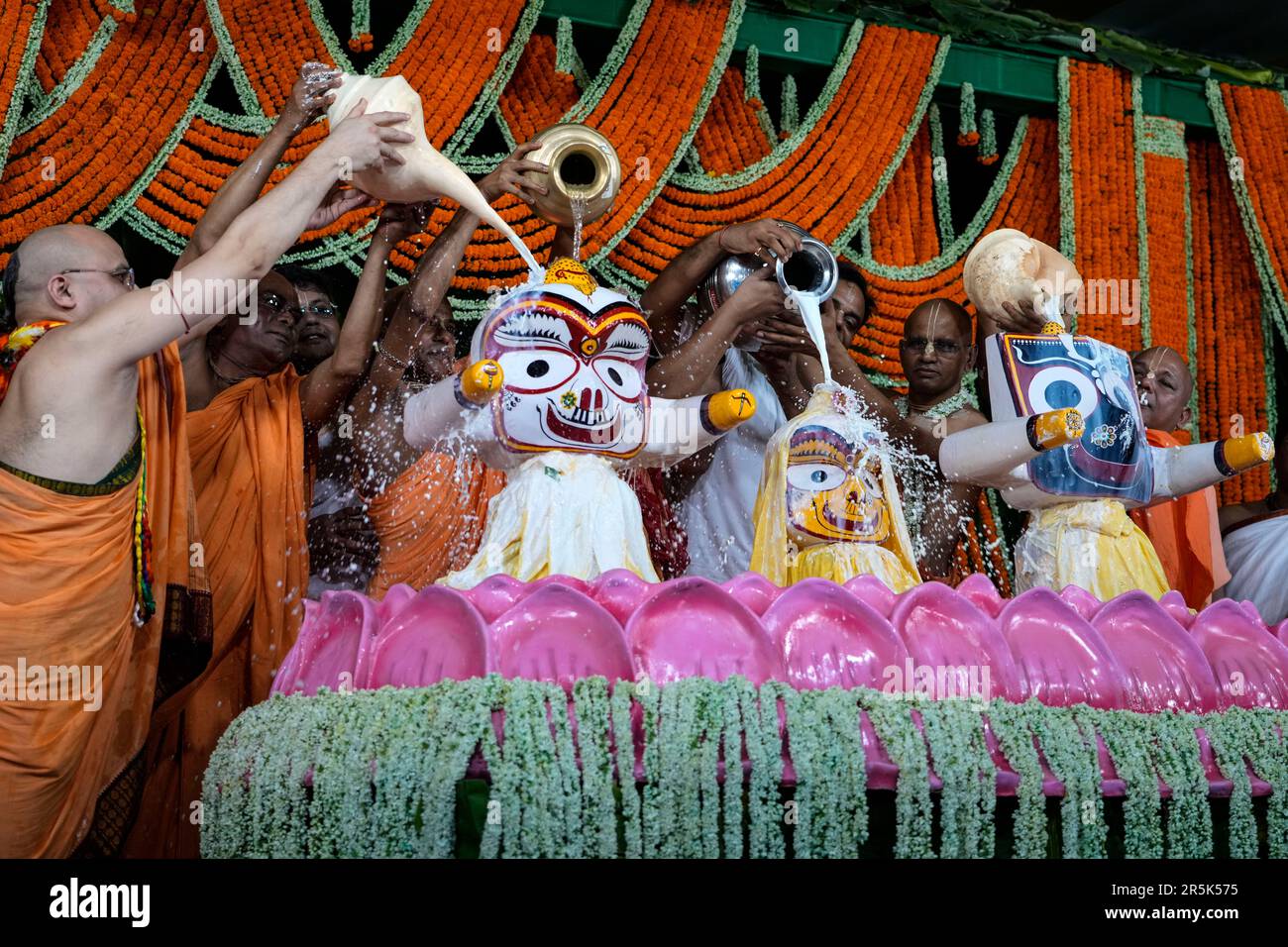 Hindu priests pour milk on the idols of Hindu deities of Jagannath ...
