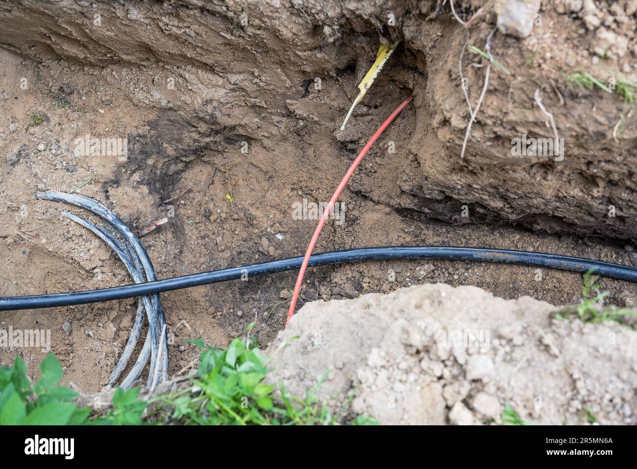 Différents câbles pour l'électricité et la fibre optique sont emmêlés ...