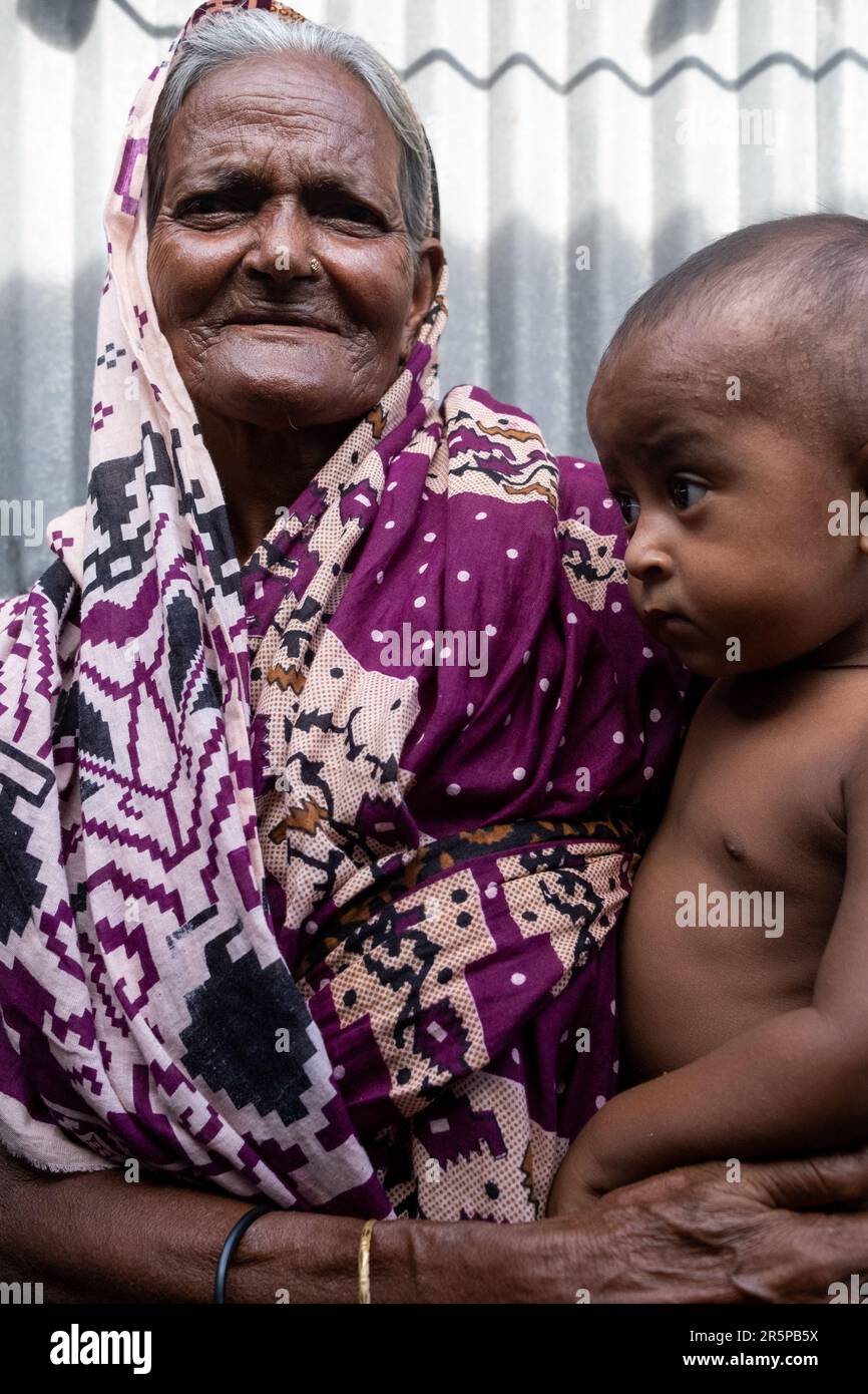 Portrait d'une femme bangladaise portant un enfant. Le bidonville de ...