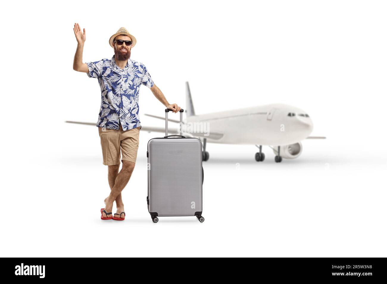 Portrait en longueur d'un touriste posant avec une valise devant un avion et agitant isolé sur ...