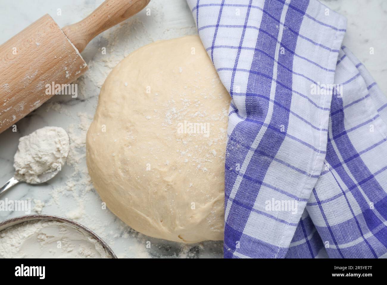 Pâte de levure fraîche avec farine sur une table en marbre blanc, à ...