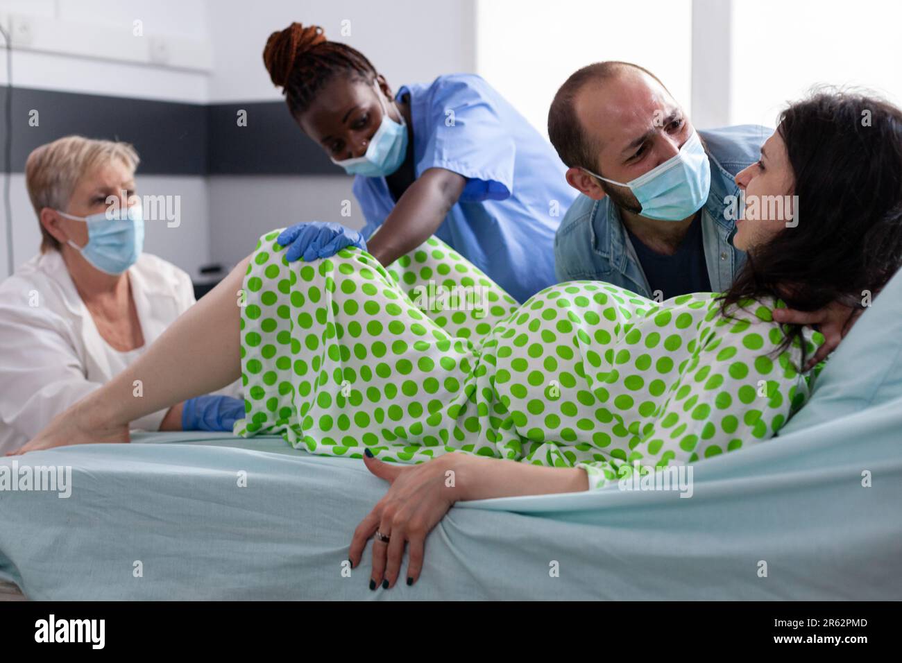 Future mère accouchement enfant dans la salle d'hôpital, équipe médicale et mari réconfortant le ...
