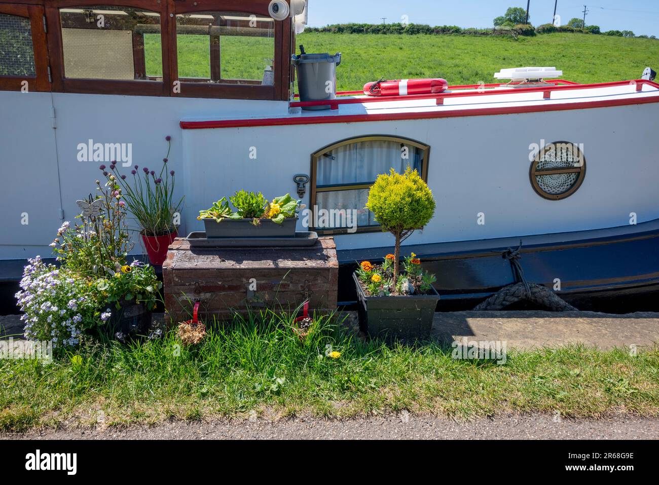 Petit jardin à côté d'un bateau à rames du canal à Calverley Bridge ...