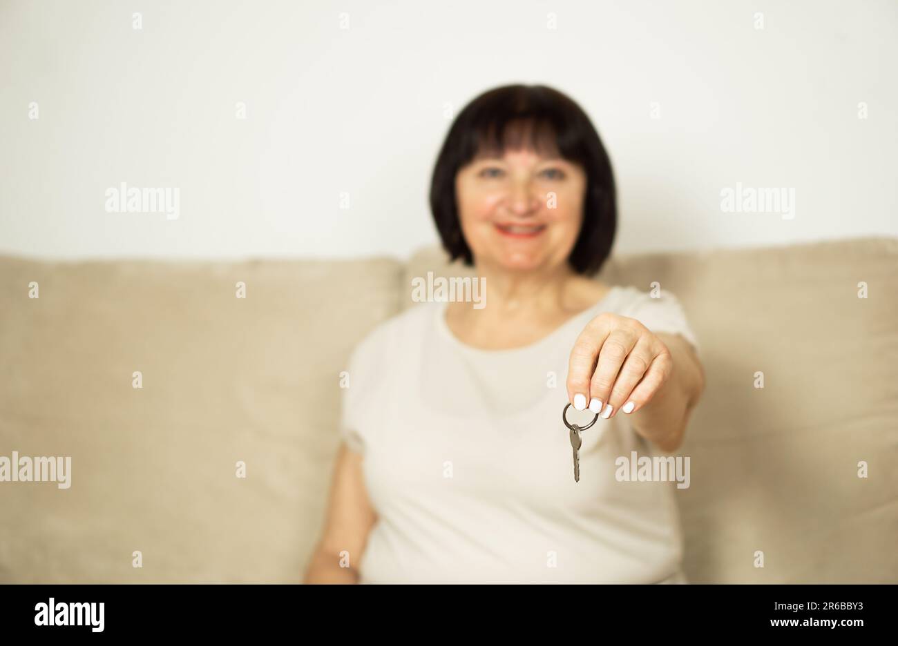 Portrait d'une jolie femme d'âge moyen et gaie tenant une clé de sa ... Portrait d'une jolie femme d'âge moyen et gaie tenant une clé de sa ...