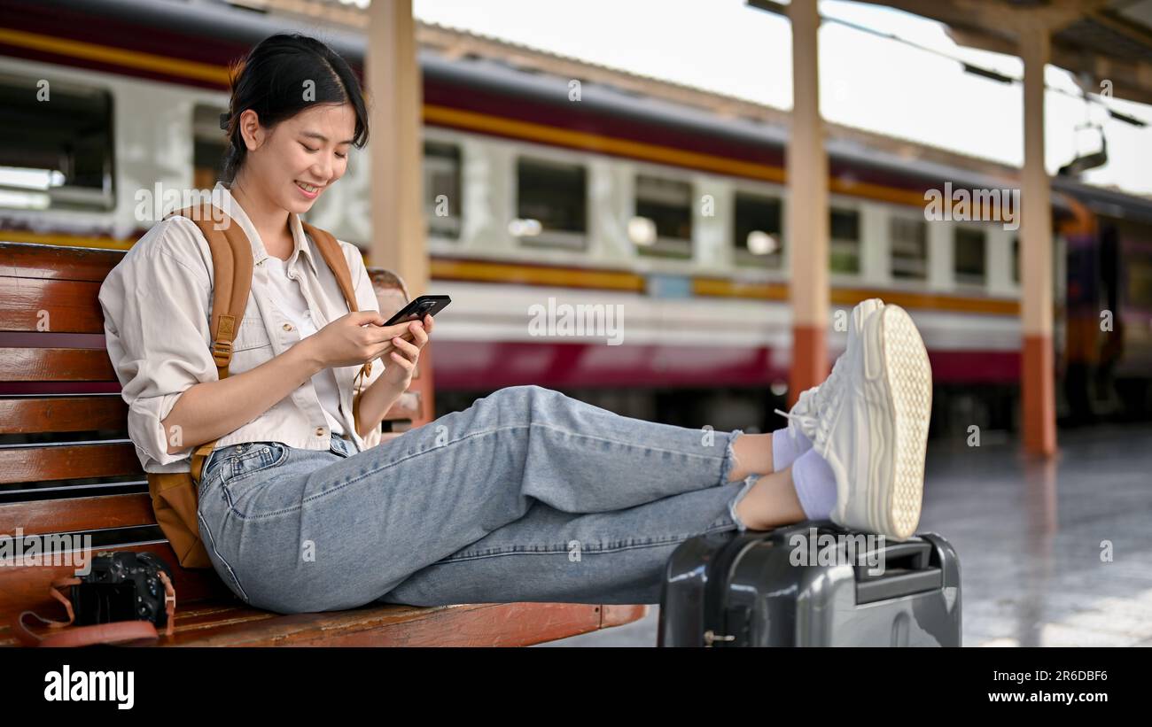 Une belle et heureuse jeune asiatique routard ou voyageur en utilisant ...