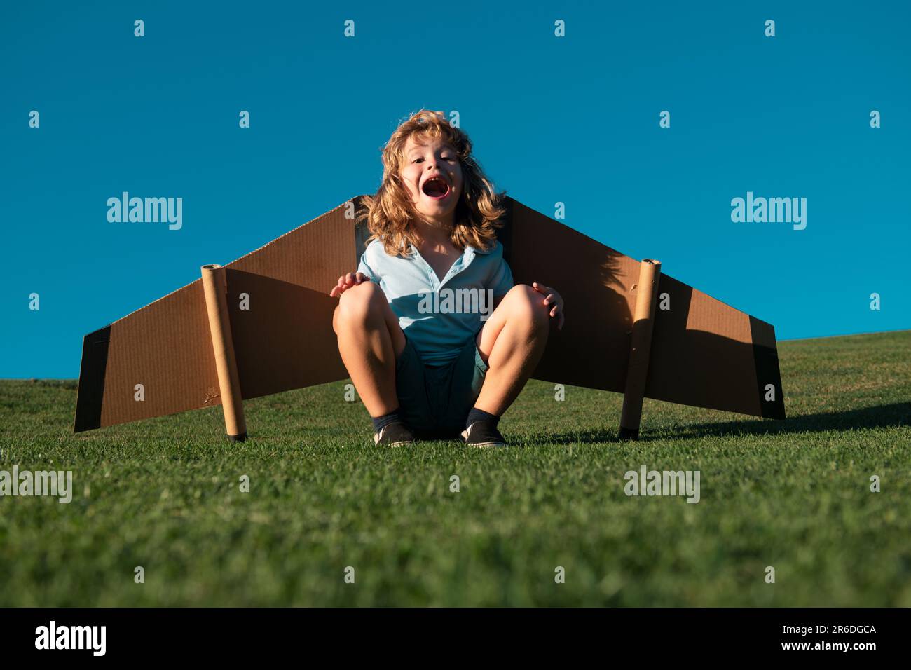 Enfant volant dans un avion fait de l'artisanat des ailes en carton ...