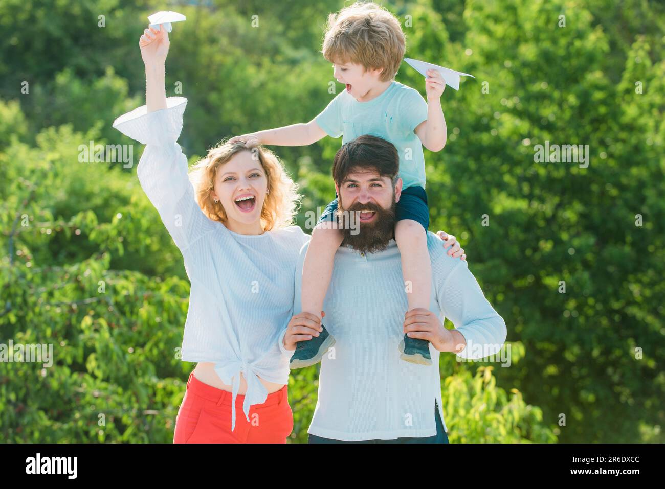 Bonne famille et petit fils jouant sur le ciel bleu d'été. Père mère et ...