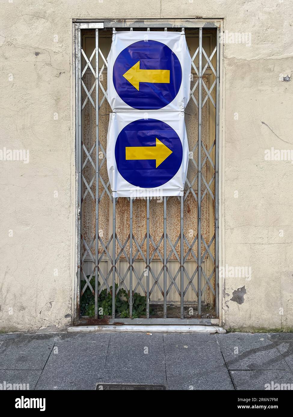 une porte rouillée avec une grille métallique, avec deux signes de ...