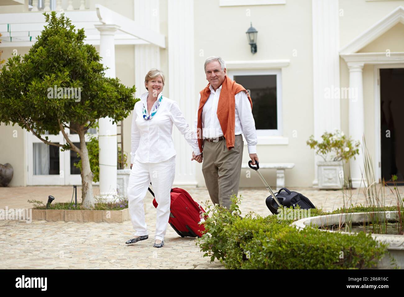 Voyage, hôtel et heureux couple senior marchant avec une valise dans un ...