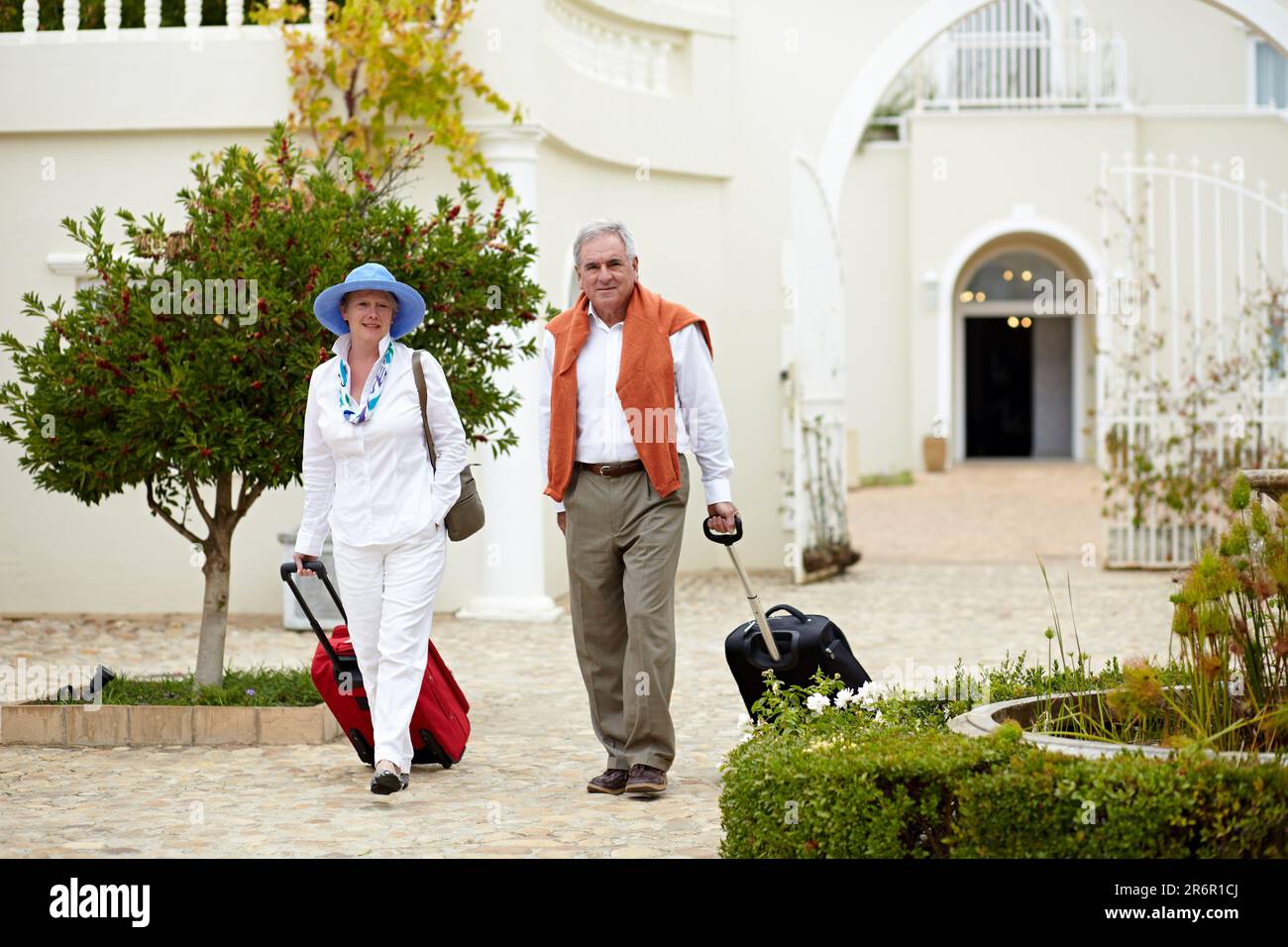 Hôtel, vacances et couple de personnes âgées marchant avec une valise ...