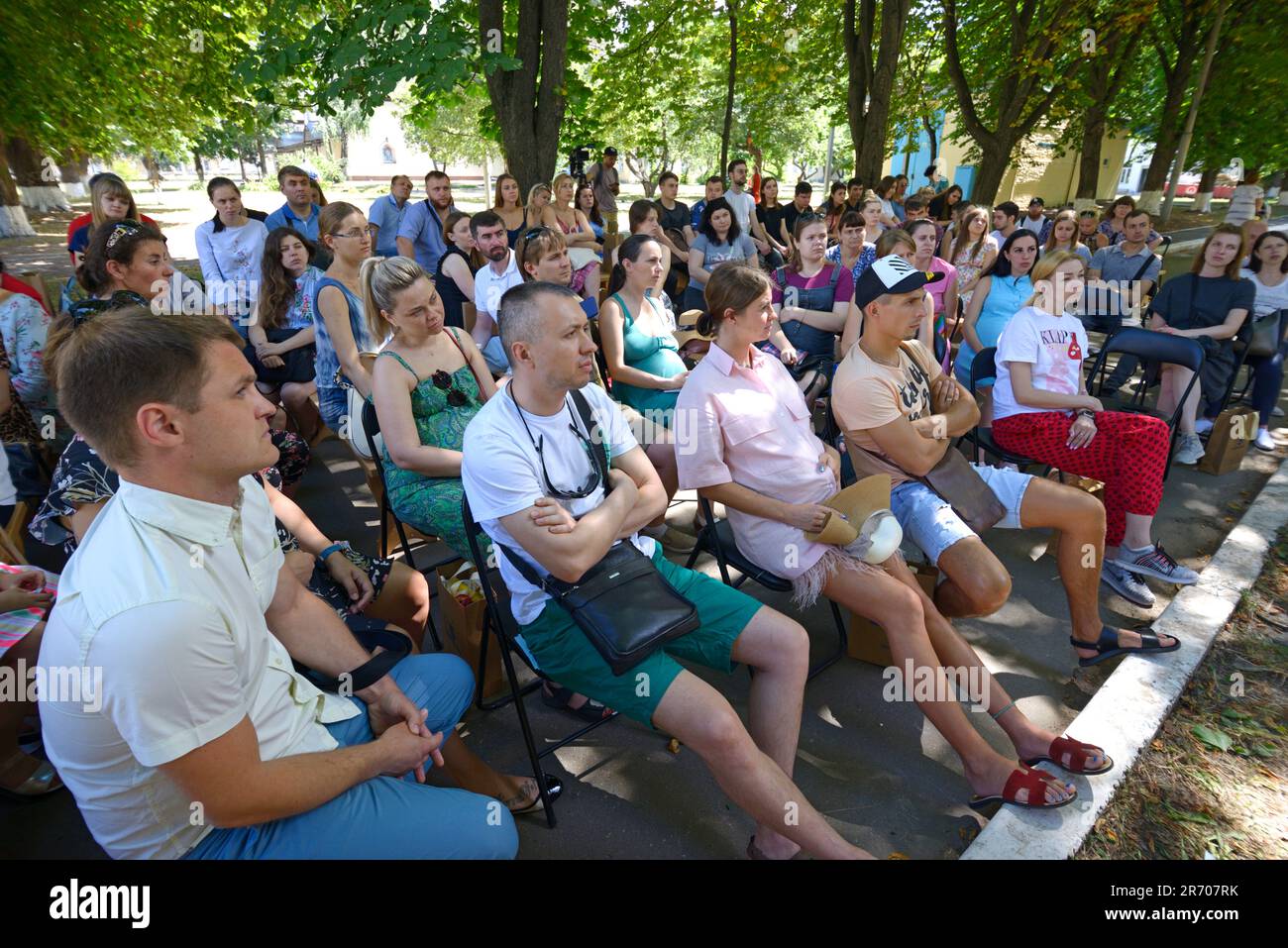 Groupe de femmes enceintes et de leurs maris assis sur des bancs à l ...