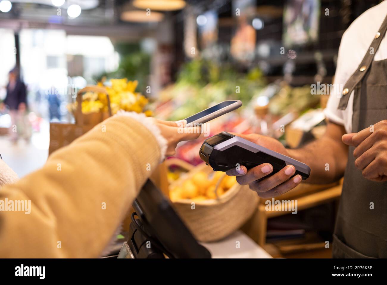 Un homme méconnaissable se tenant au comptoir avec un terminal de point ...