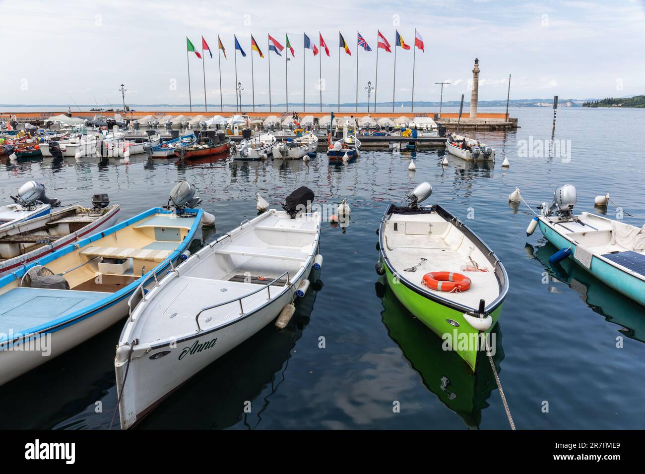 Port de Garda avec drapeaux européens sur les mâts au mur du port ...