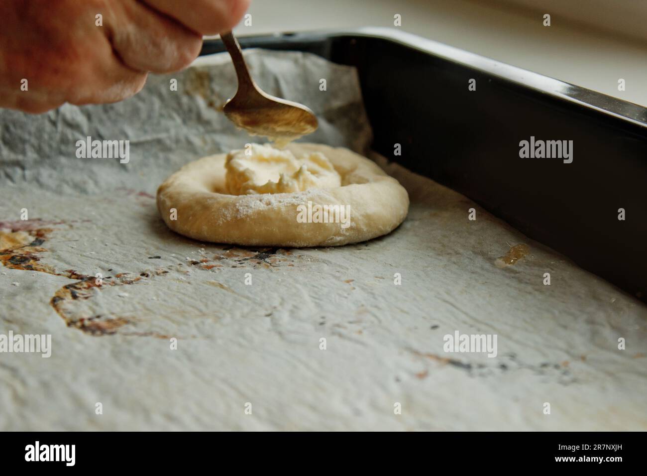 la pâte pétrie crue repose dans le sol. la main femelle verse le ...