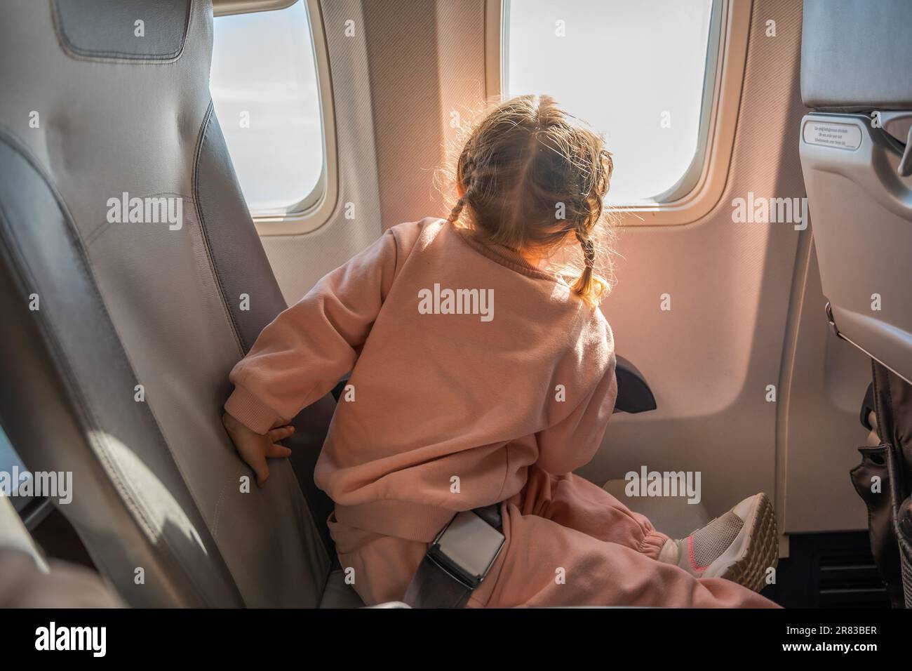 Petite fille mignonne voyageant à bord d'un avion. Enfant assis près de ...