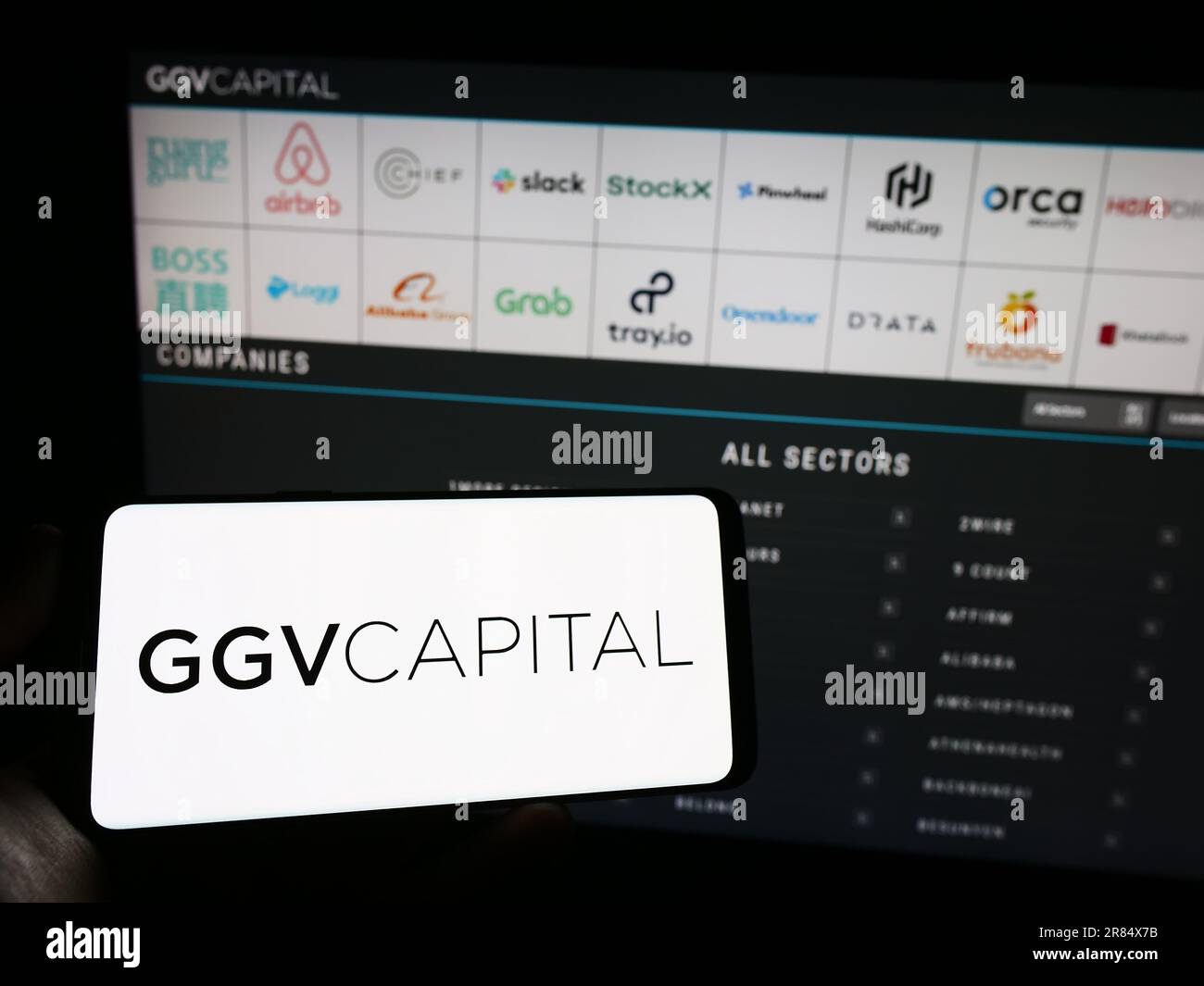 Personne tenant le téléphone mobile avec le logo de la société d'investissement GGV Capital sur ...