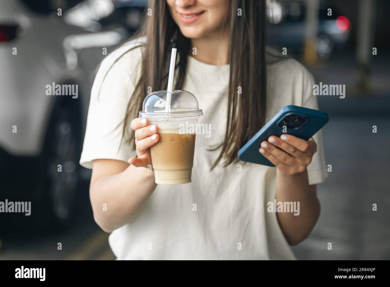 Une femme tient le café et une personne intelligente dans ses mains ...