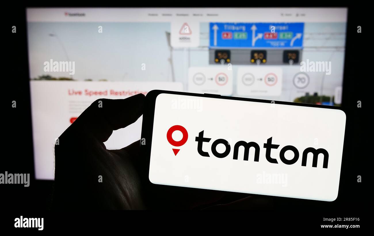 Personne tenant un téléphone portable avec le logo de la société néerlandaise de technologie de ...