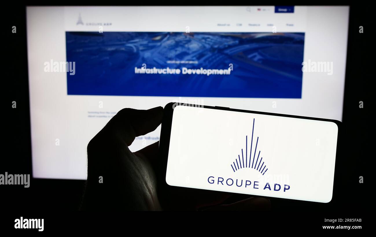 Personne tenant un téléphone portable avec le logo de l'entreprise ...