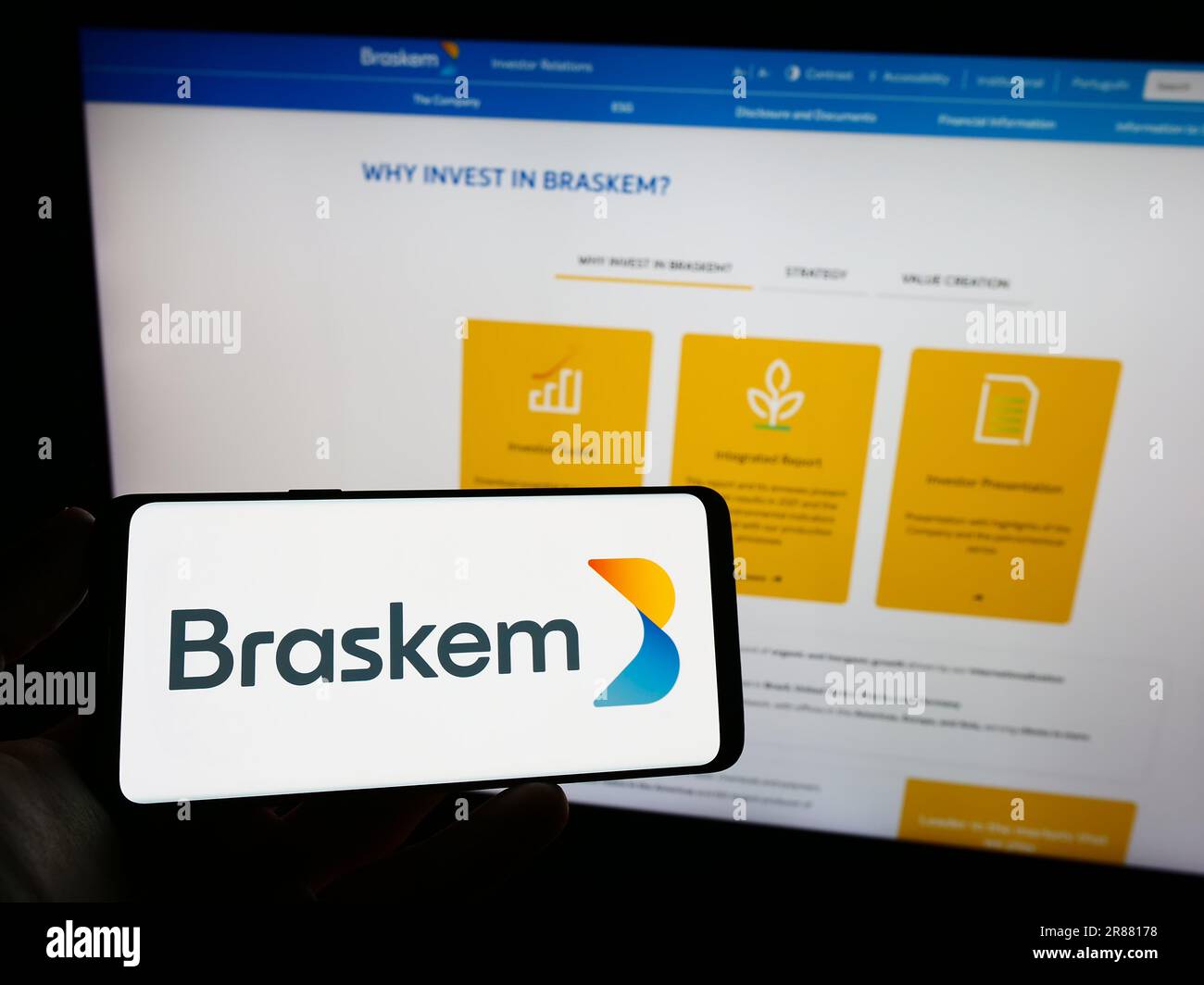 Personne tenant un téléphone portable avec le logo de la société pétrochimique brésilienne ...