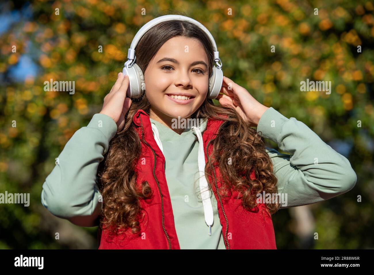 une jeune fille sourit et écoute de la musique. jeune fille écoutant de ...