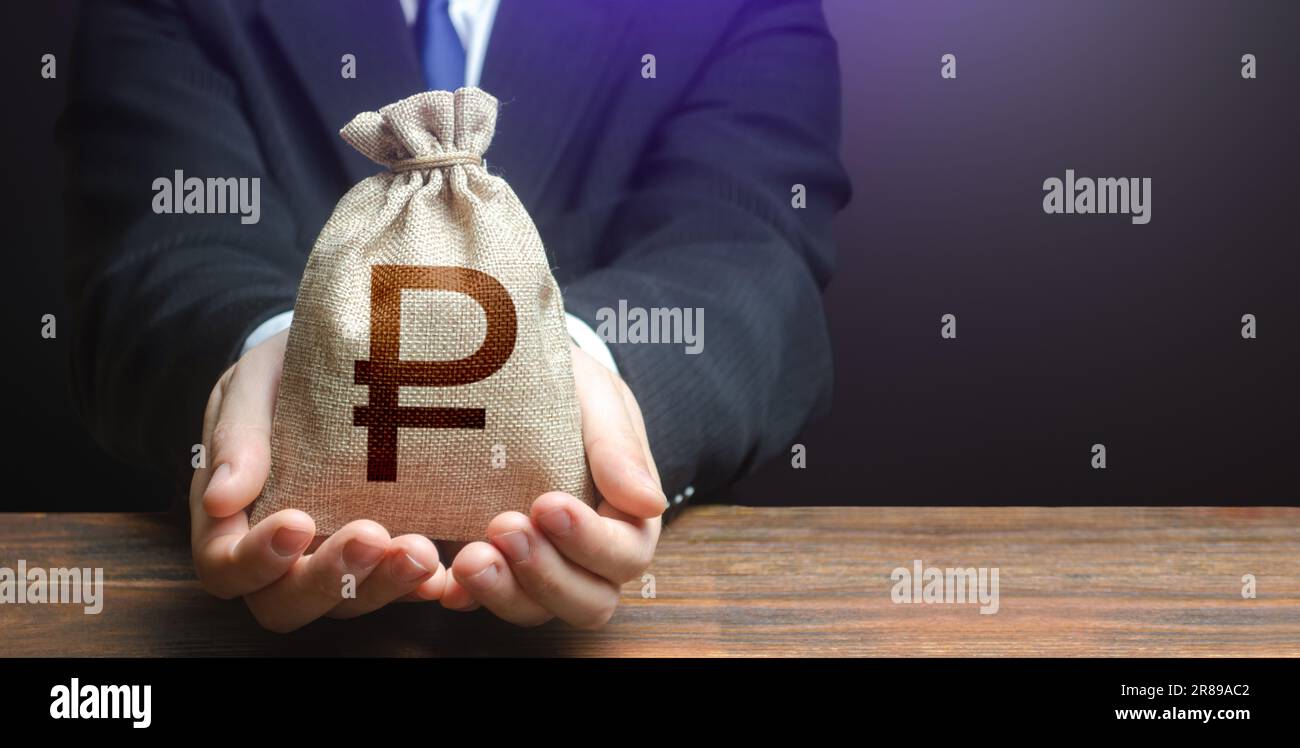 L'homme d'affaires tient le sac d'argent du rouble russe. Obtenir une ...