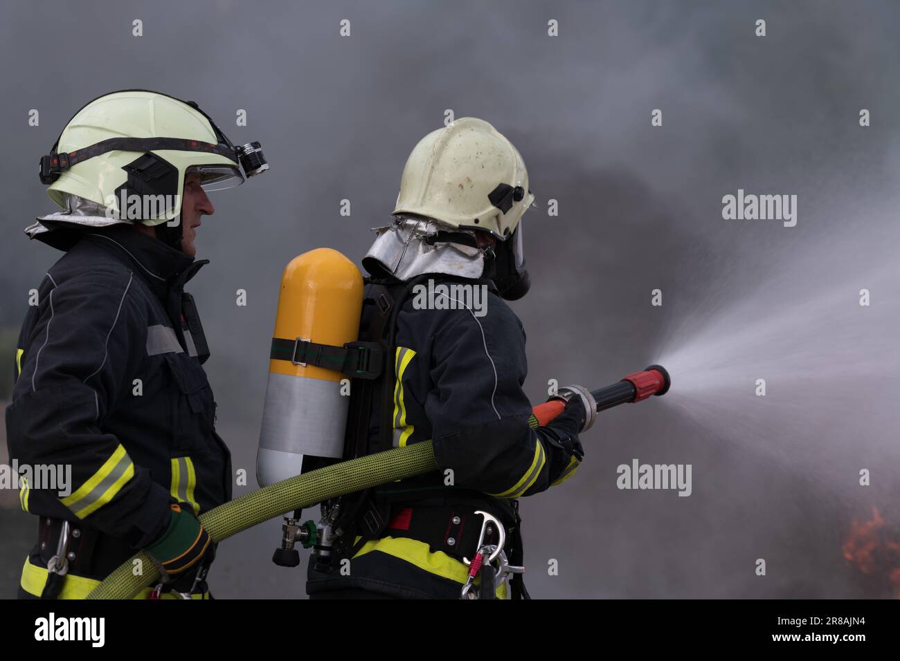 Les pompiers utilisant un extincteur de type brouillard d'eau pour ...