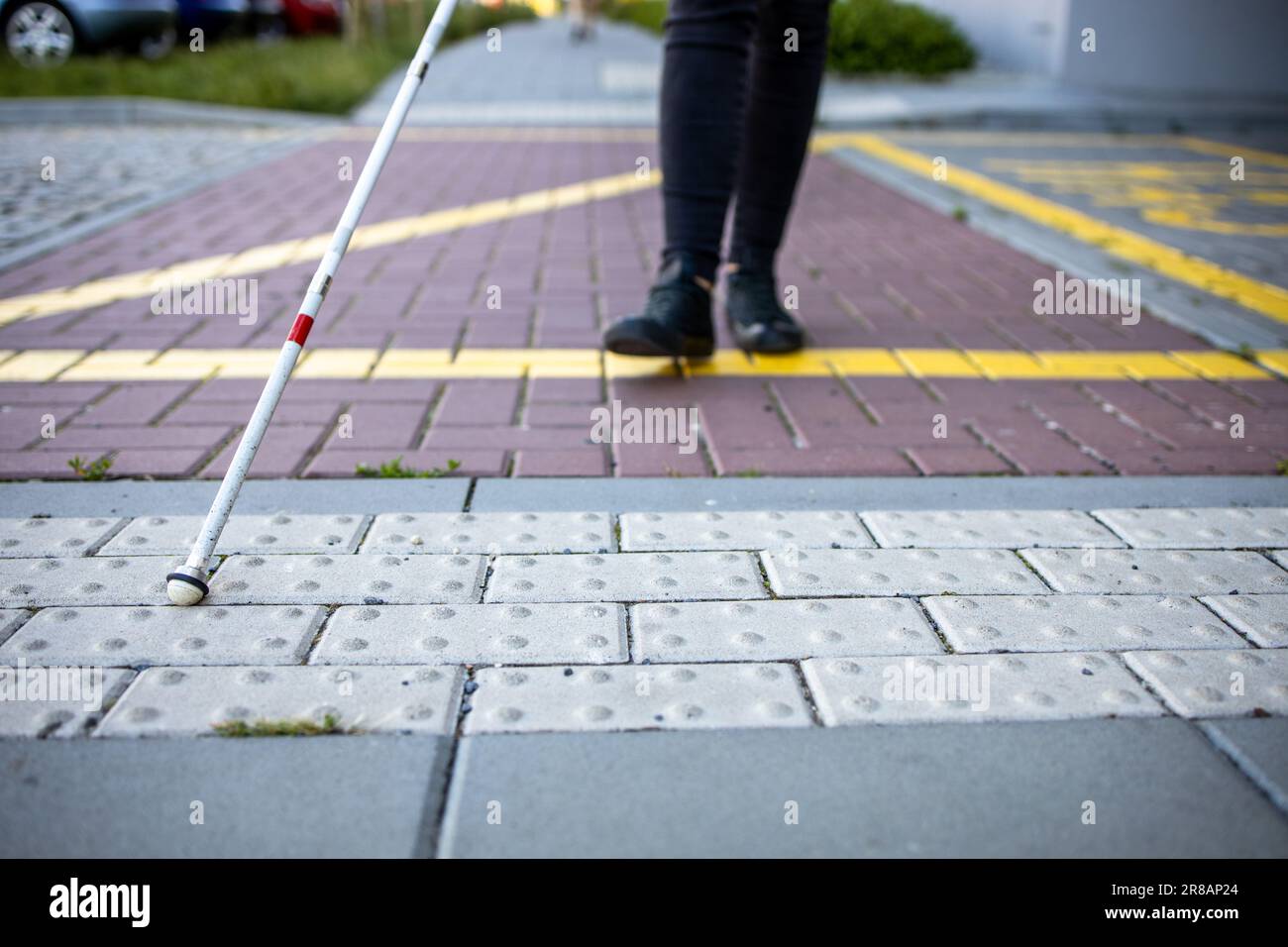 Femme aveugle marchant dans les rues de la ville, utilisant sa canne ...
