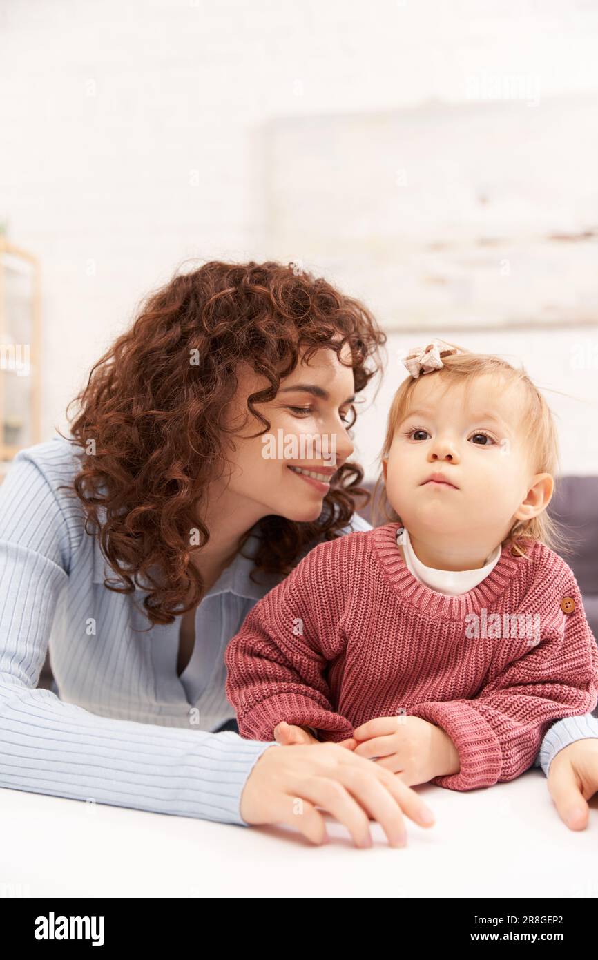 portrait de la femme et de l'enfant joyeux, la mère au travail bouclé ...
