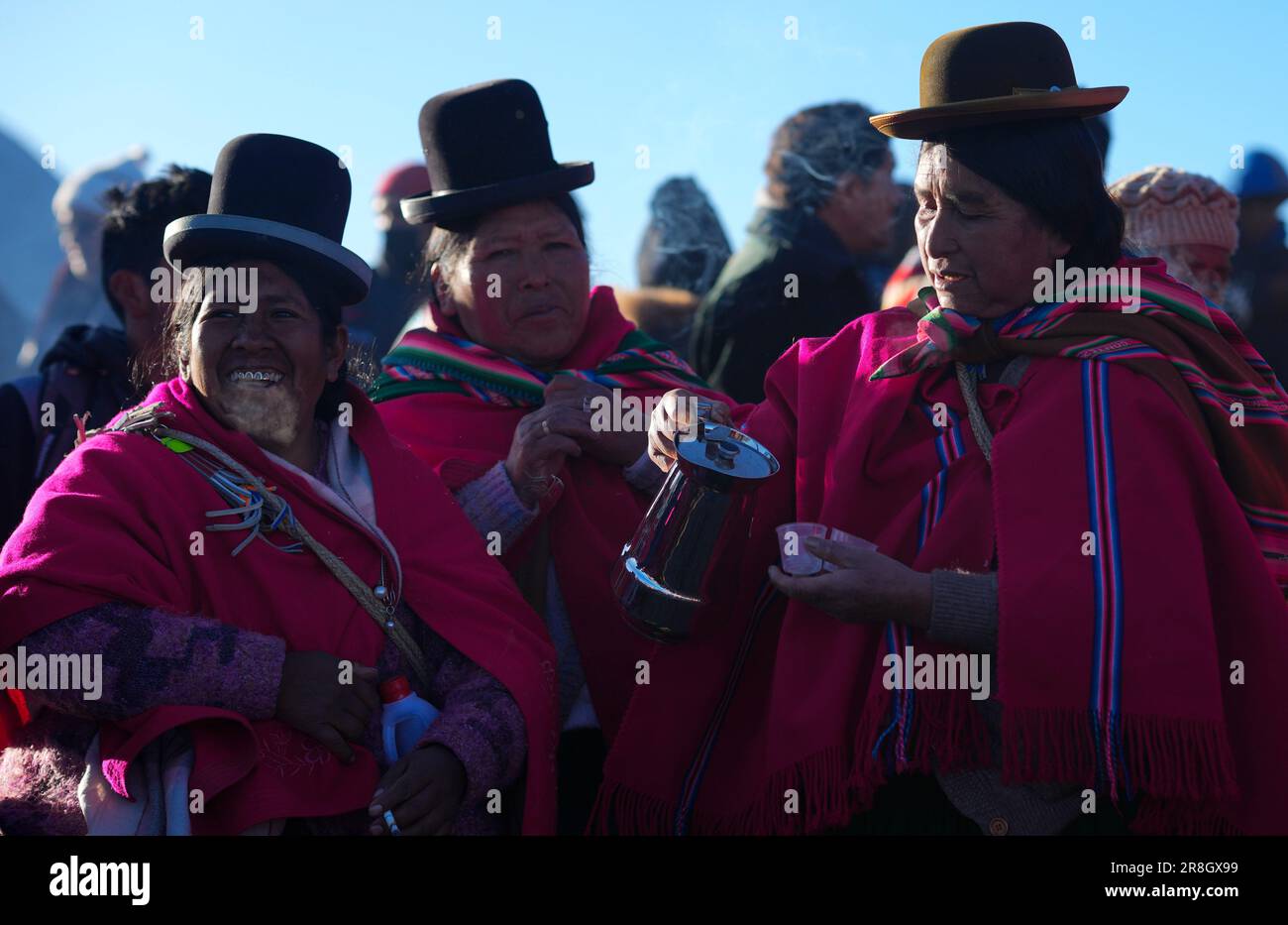 Aymara Indigenous women pass around a coffee pot after receiving the ...