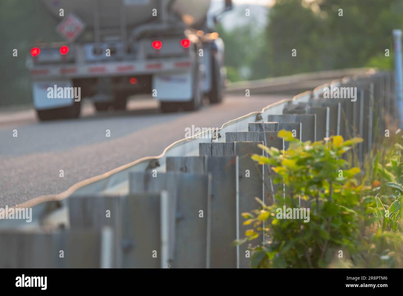 clôture routière avec arrière-plan flou du camion de carburant passant ...