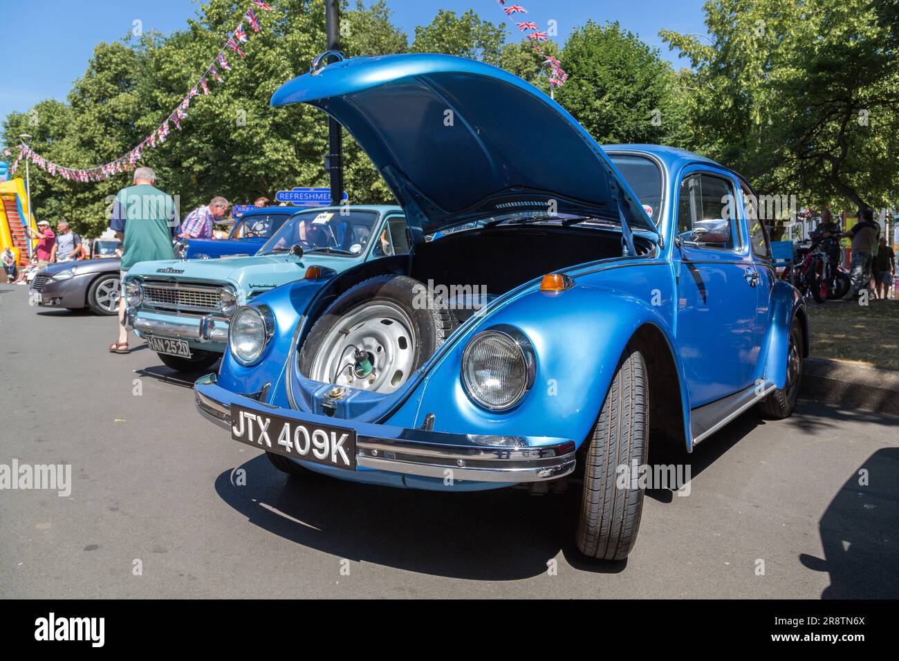 Une Volkswagen Beetle bleue des années 1970 avec un coffre ouvert affichant la roue de secours ...