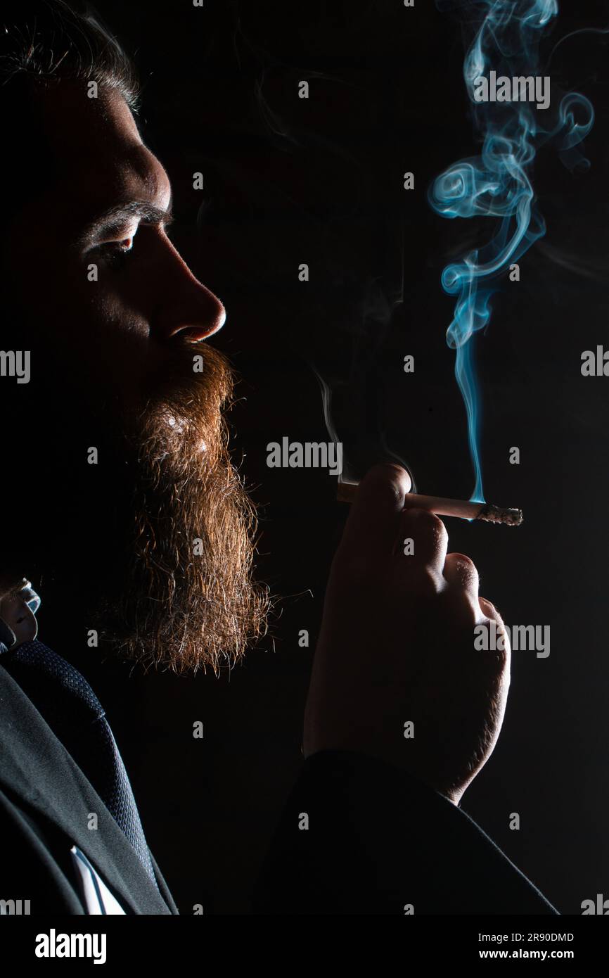 Homme fumant de la cigarette. Fumée sur fond noir. Fumée de cigarette ...