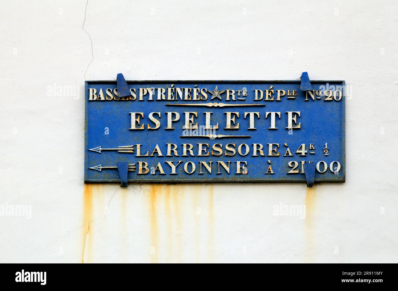 Plaque de direction sur un mur au centre du village. Espelette ...