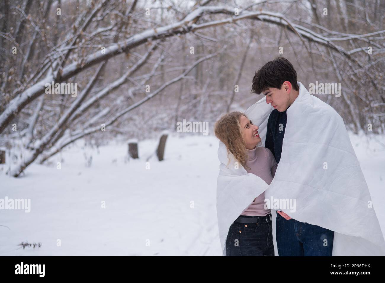 Un jeune couple marche dans le parc en hiver.Le gars et la fille sont ...