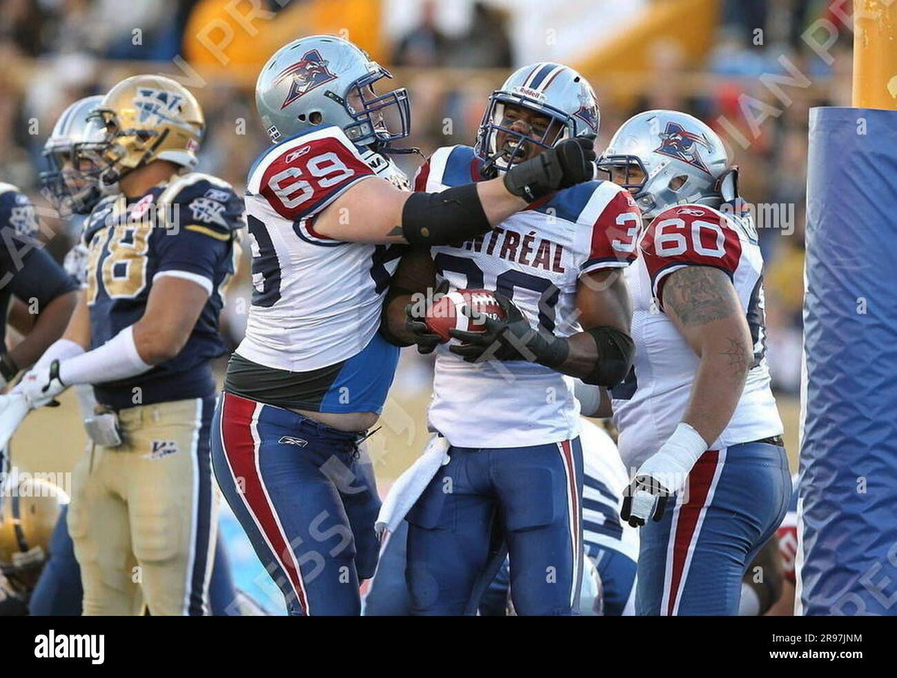 FILE - Montreal Alouettes running back Dahrran Diedrick, center, and ...