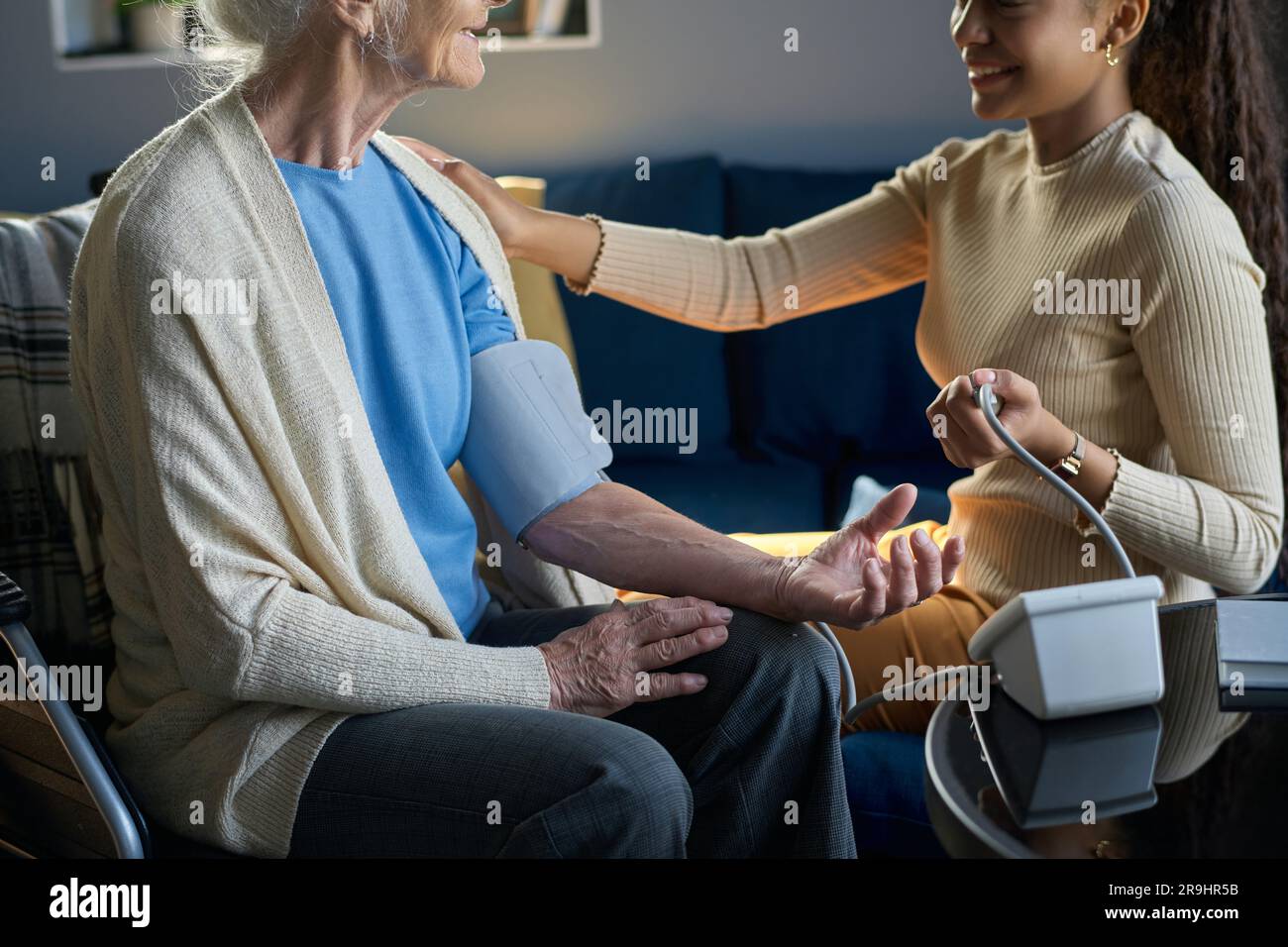 Prise de vue rognée d'une adolescente souriante mesurant la tension ... Prise de vue rognée d'une adolescente souriante mesurant la tension ...