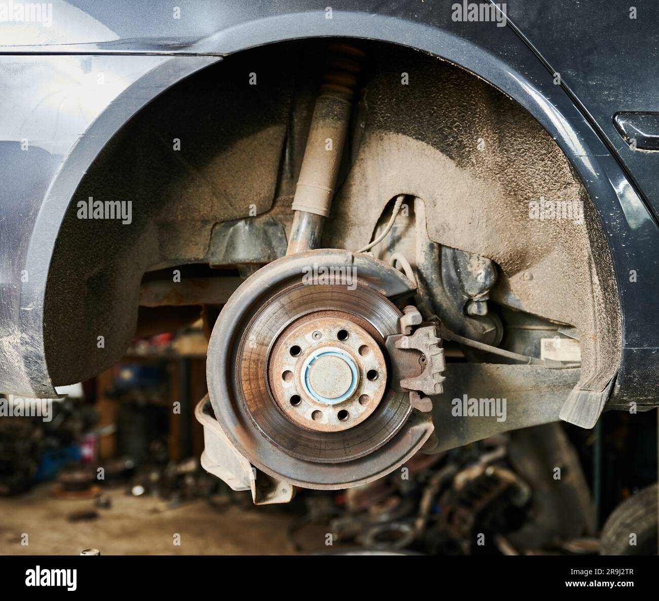 Gros plan d'un employé qui change la roue de sa voiture dans un garage, un centre d'entretien de ...