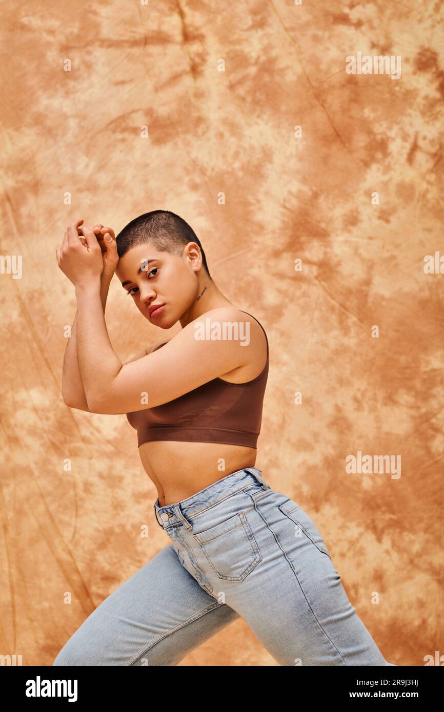 denim mode, gen z, jeune femme curvy avec tatouage posant sur fond ...