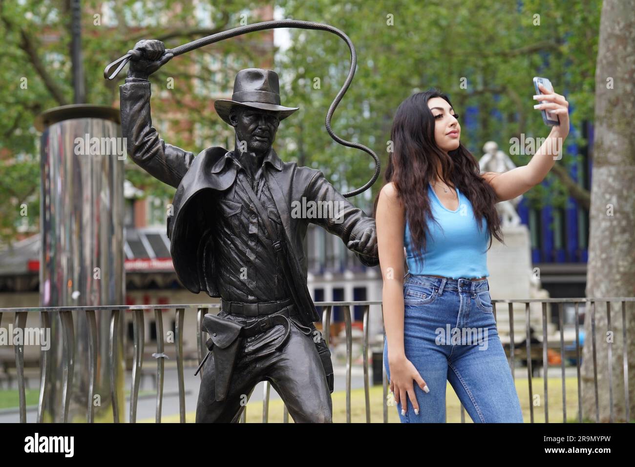 Une personne prenant un selfie avec une statue en bronze grandeur ...
