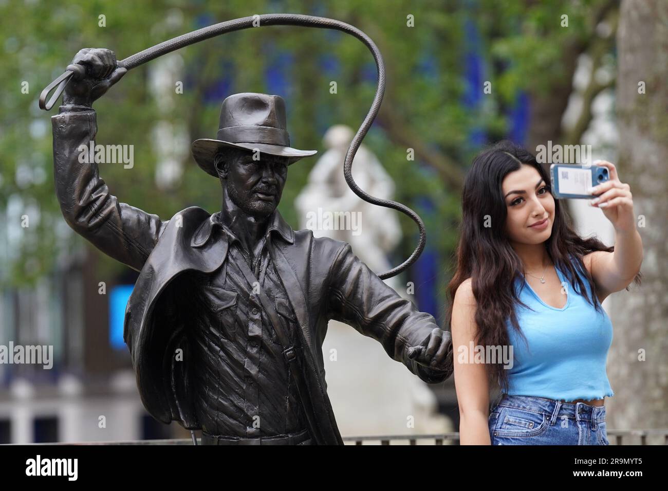 Une personne prenant un selfie avec une statue en bronze grandeur ...