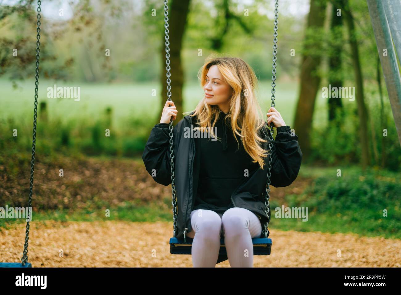 Femme joyeuse et jeune sur une balançoire au parc. Concept pf personnes ...