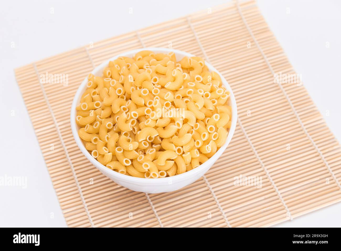Pâtes Rigati en mousseline non cuite sur une tasse blanche sur un tapis ...