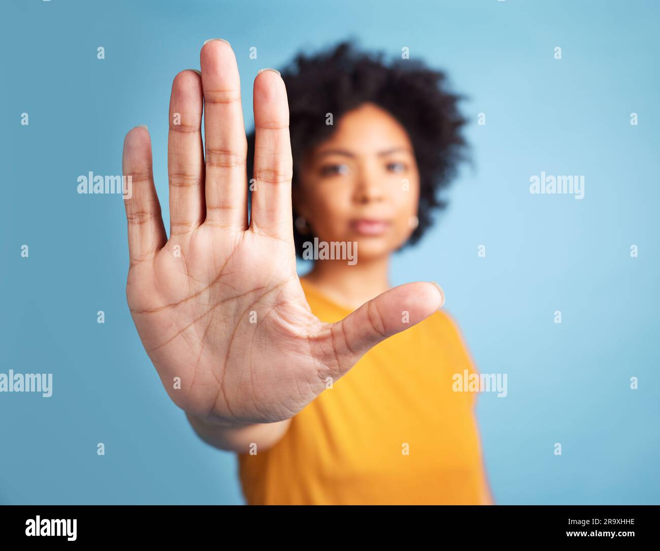 Portrait, panneau stop main et femme en studio isolé sur un fond bleu ...