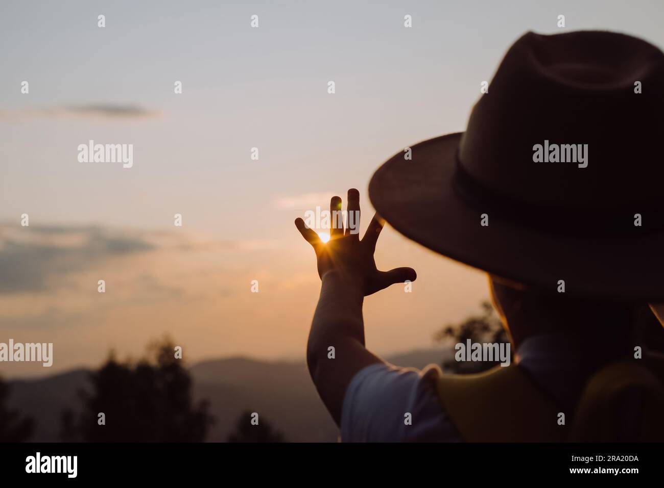Silhouette de petite fille rêveuse dans le chapeau tire la main au ...