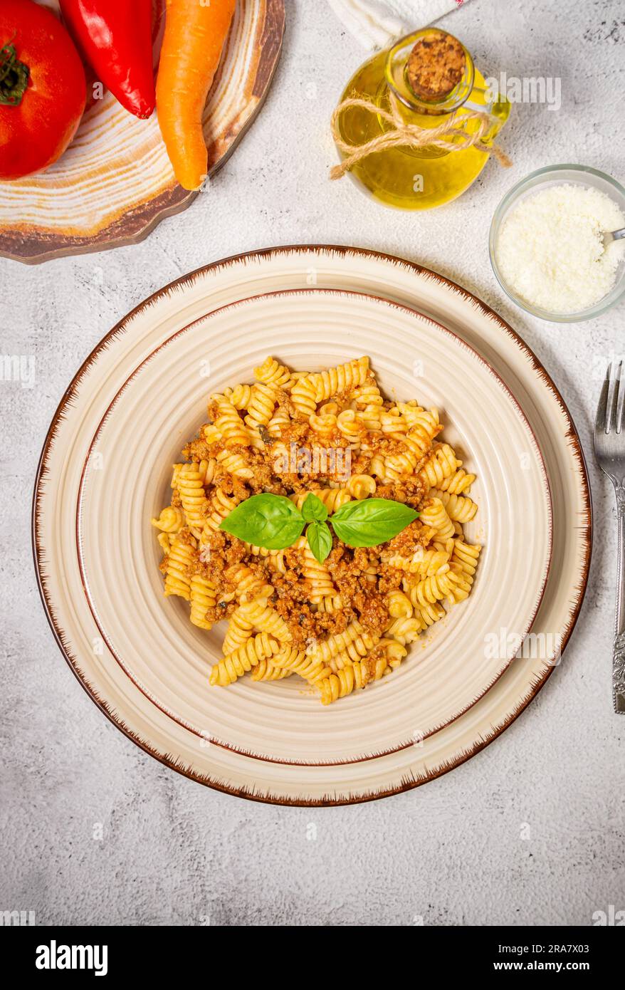 Pâtes fusilli à la viande hachée, sauce tomate, fromage et basilic ...