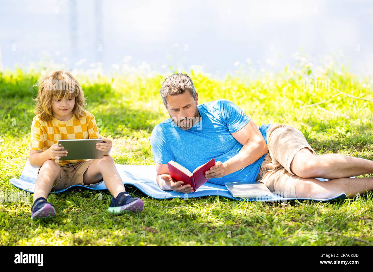 Le père forme l'éducation de son avec un livre et une tablette. Le père ...